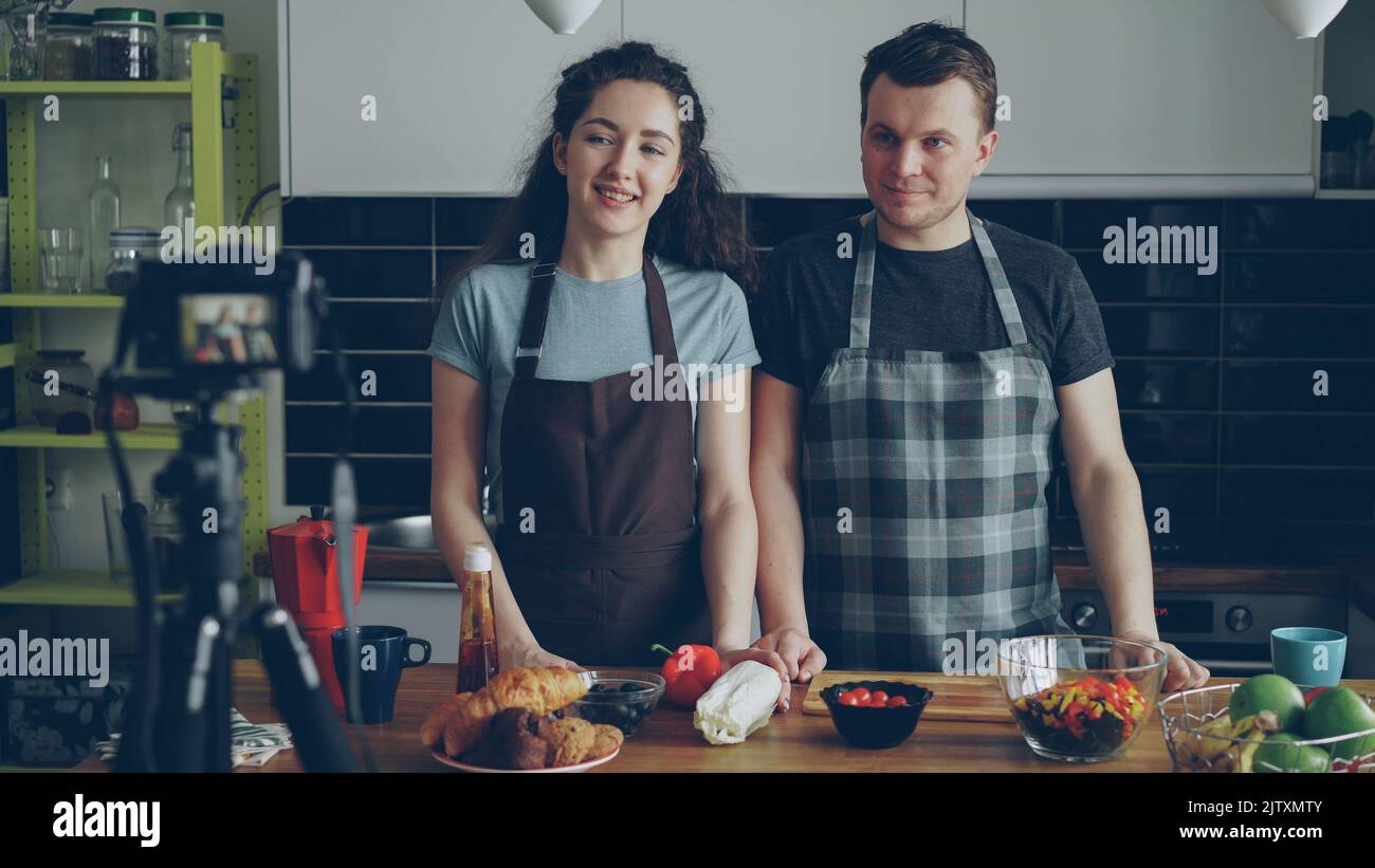 Smiling attractive couple recording video food vlog about cooking ...