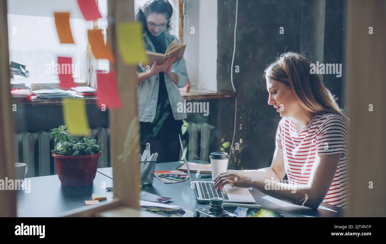 Young blond student wearing casual clothes is busy typing on laptop ...