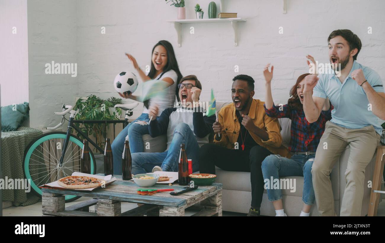 Multi-ethnic group of friends sports fans with Brazilian flags watching ...
