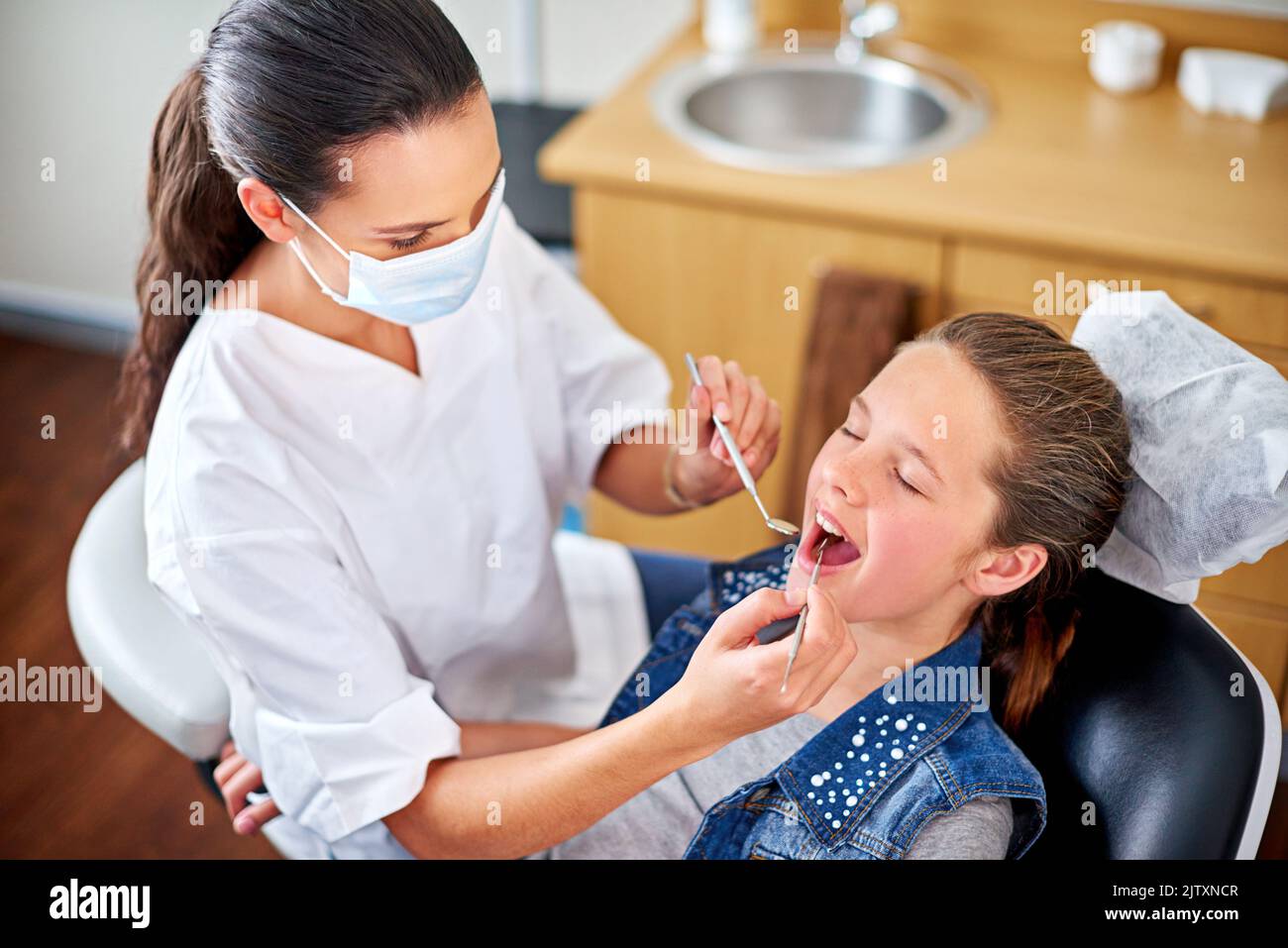 The teeth expert. Shot of a female dentist examining a little girls ...