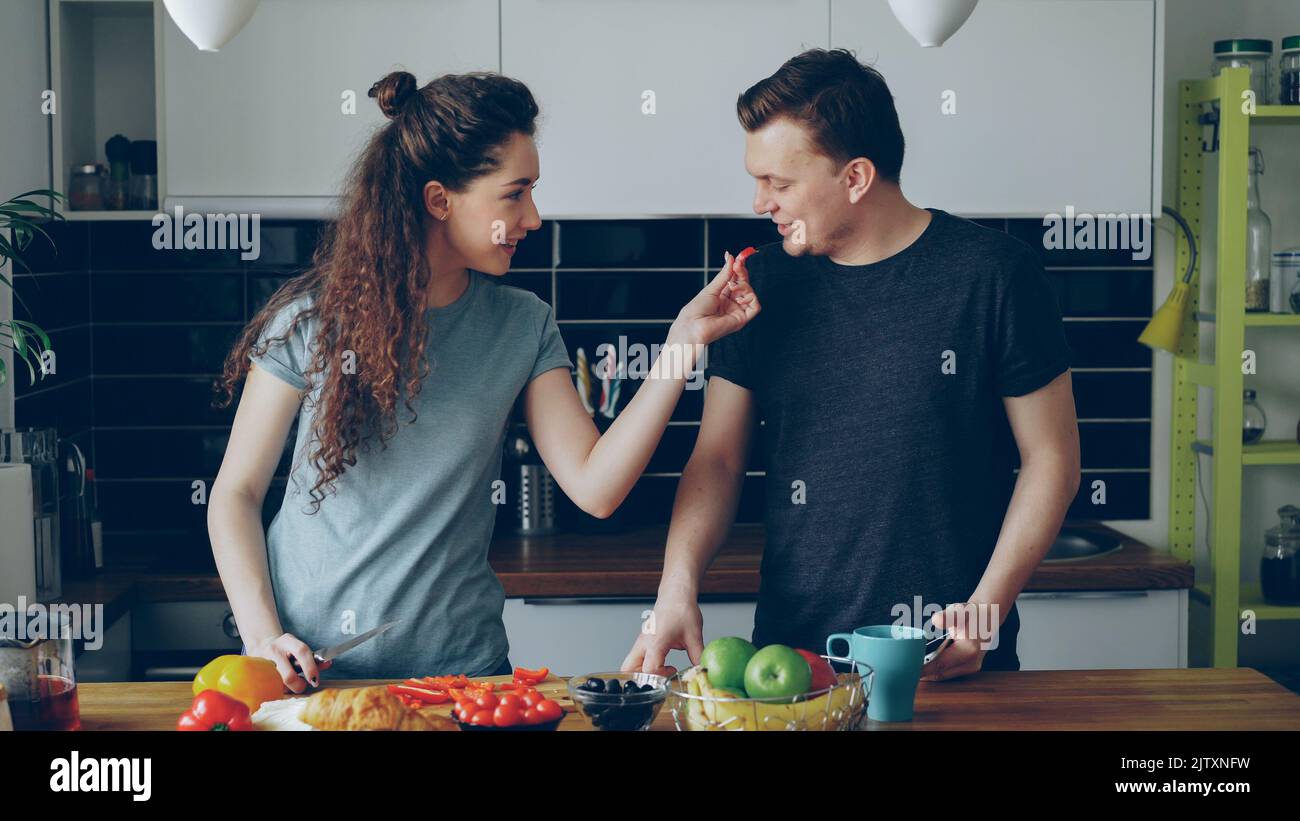 positive young caucasian couple have fun cooking in kitchen at home ...
