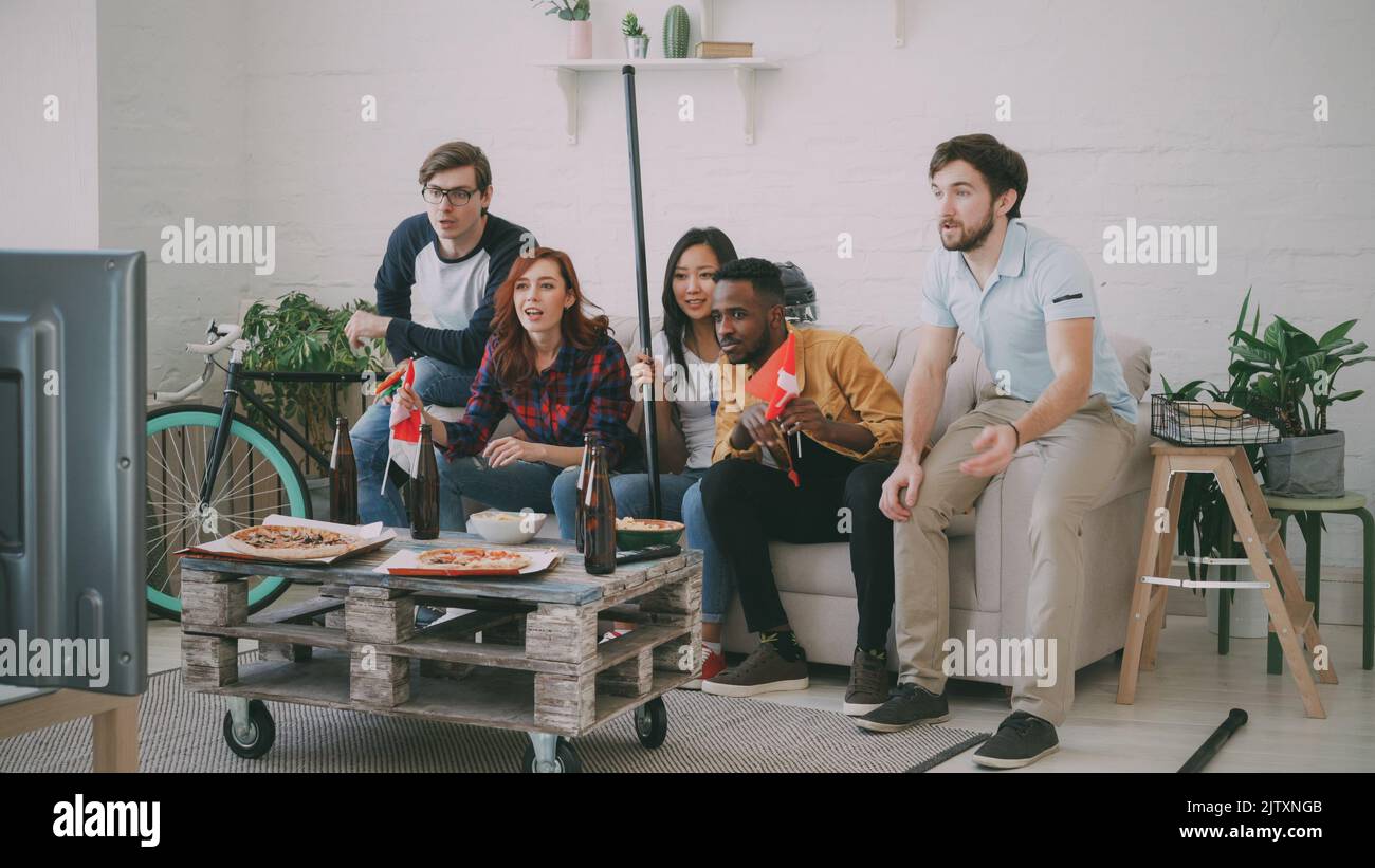 Multi ethnic group of friends sports fans with Swiss national flags ...