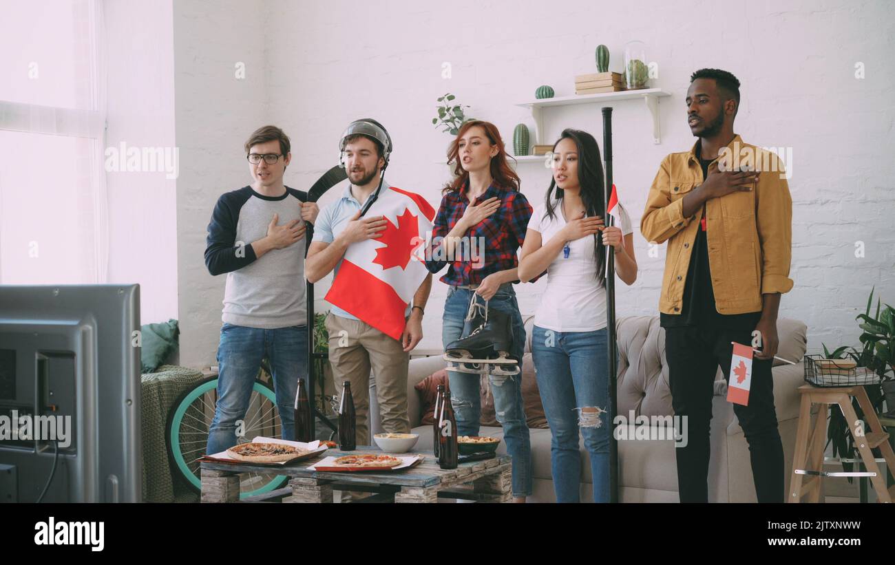 Multi ethnic group of friends sport fans listening and singing national ...