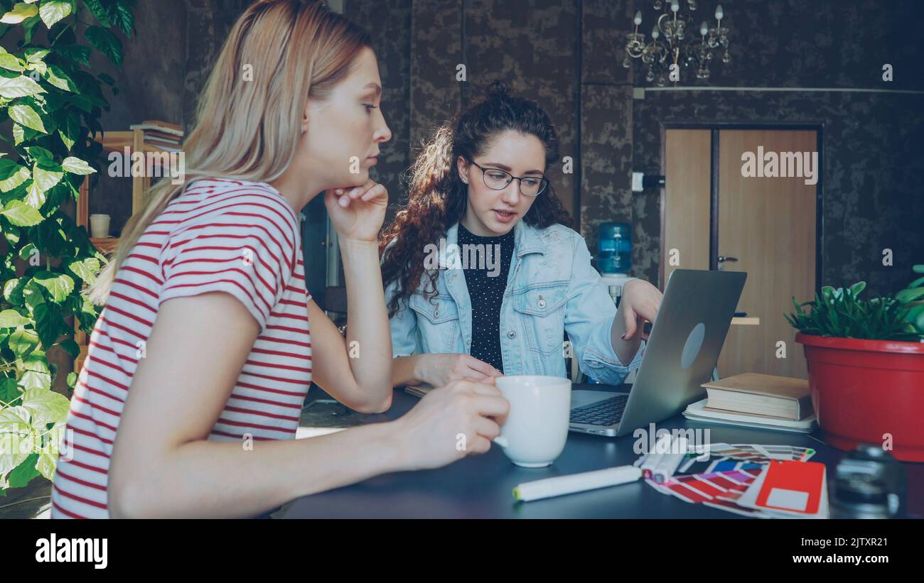 Attractive female coworkers are working at project together watching ...