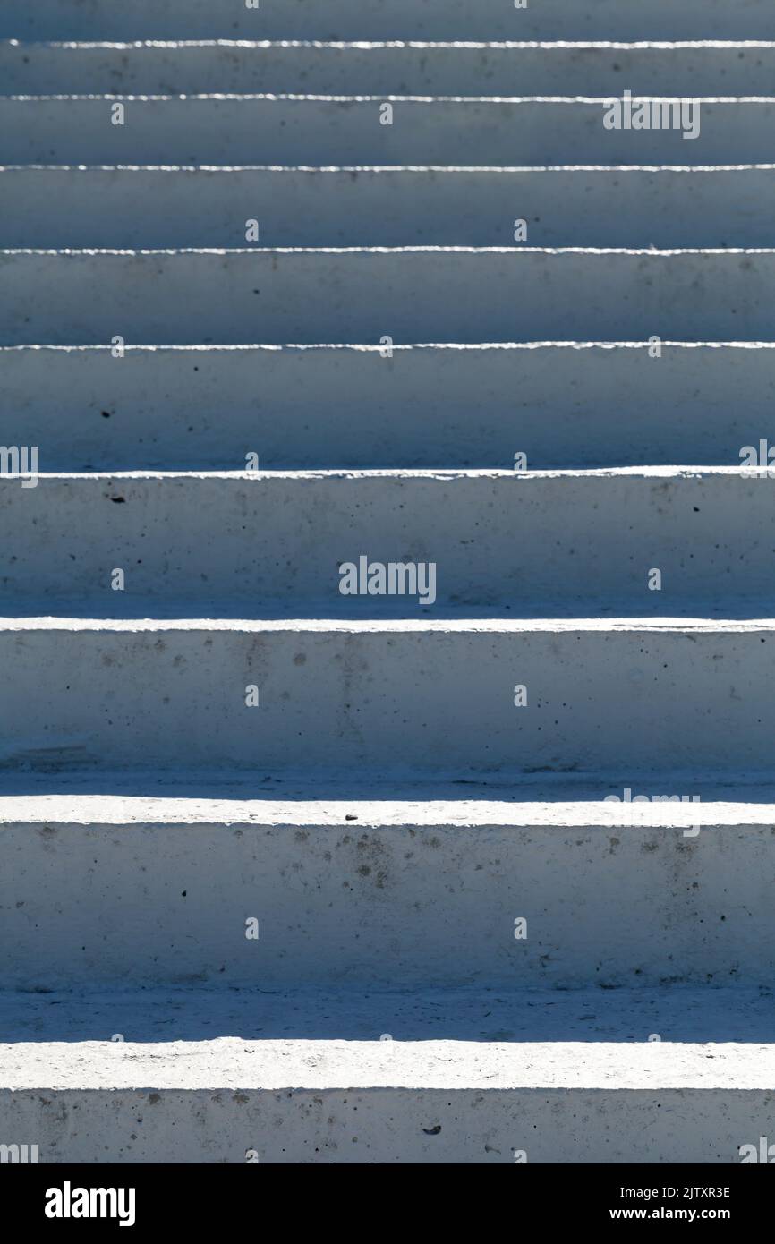 White concrete stairs with blue shadows, front view, abstract vertical ...