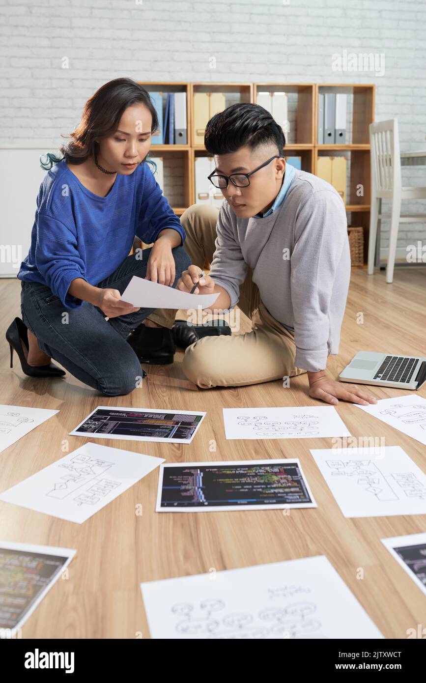 Business colleagues examining documents on the floor Stock Photo - Alamy