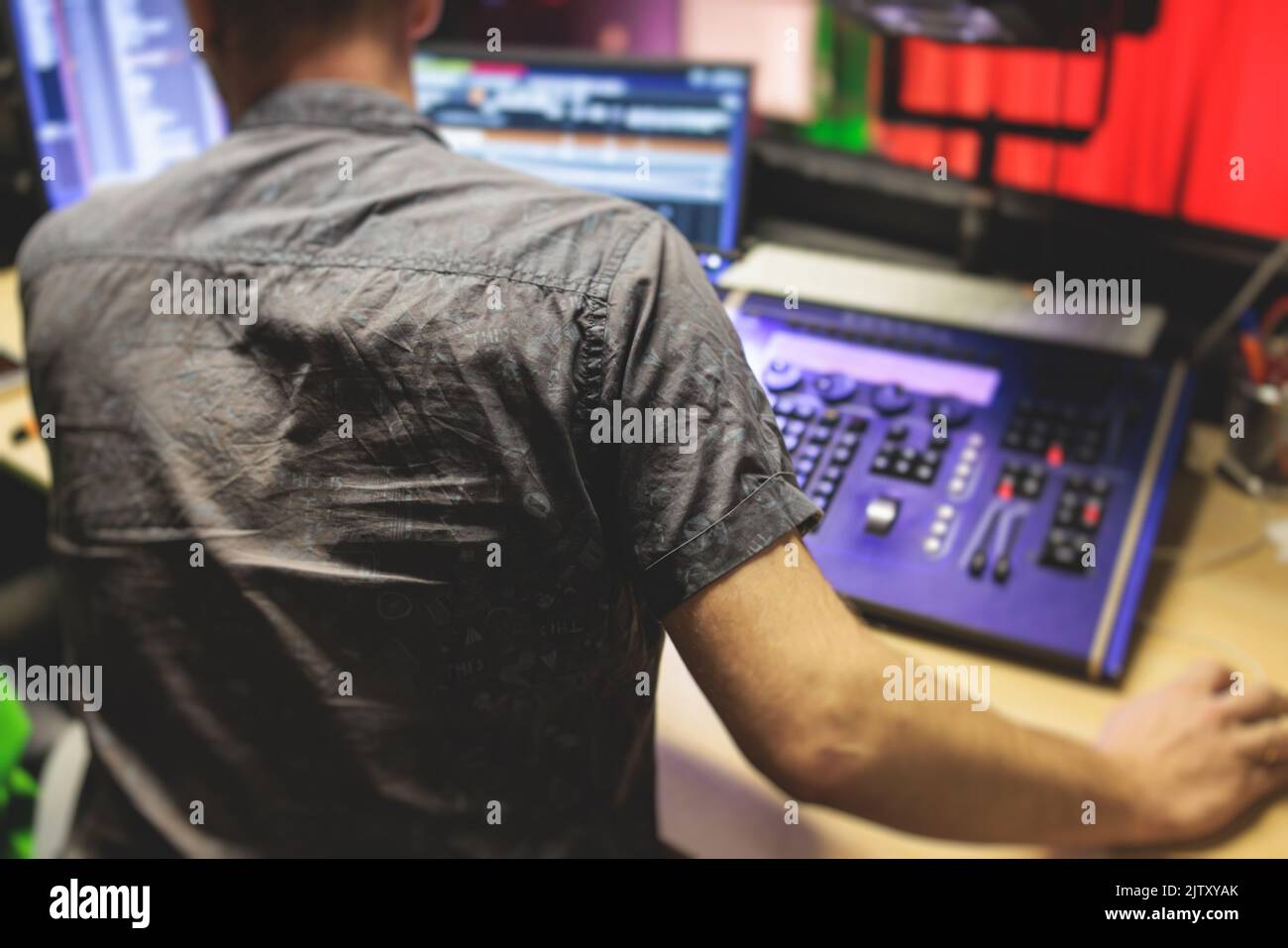 View of lighting technician operator working on mixing console ...