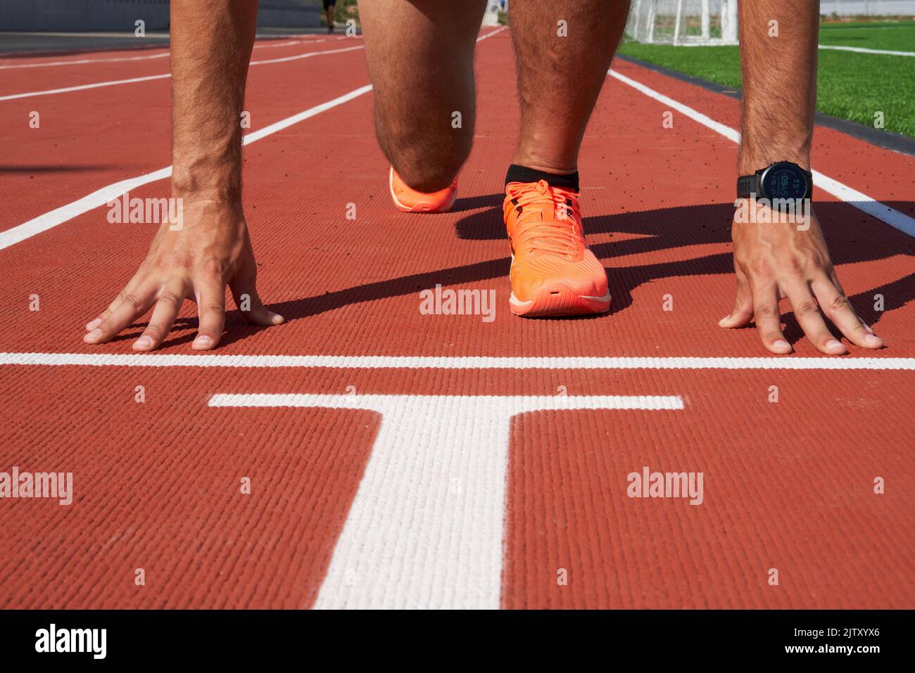 Hands on the starting line, the sprinter is preparing to start at the ...