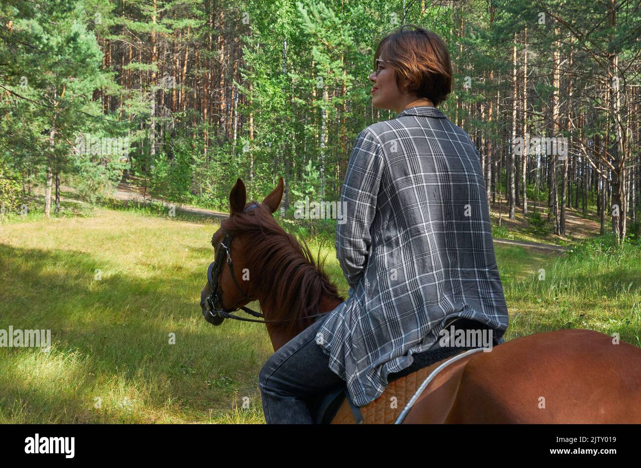 Woman in casual clothes rides a horse in hot summer day Stock Photo - Alamy