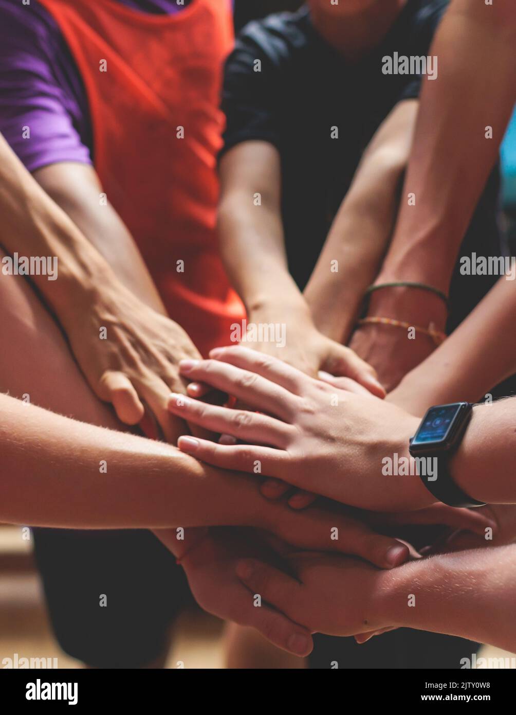 Team of kids children basketball players stacking hands in the court ...