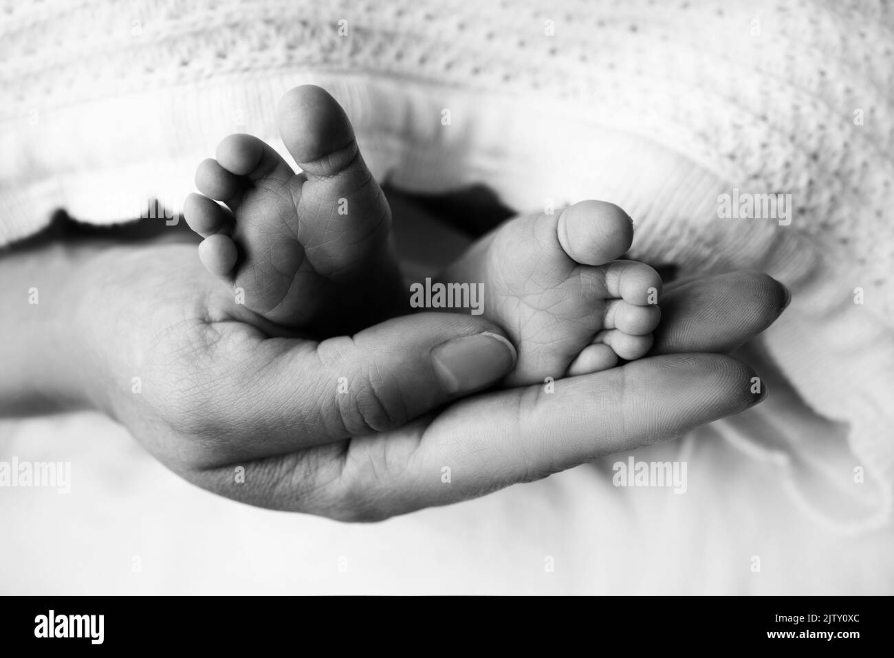 Mother hold the legs of newborn baby. Feet of a newborn in the hands of ...