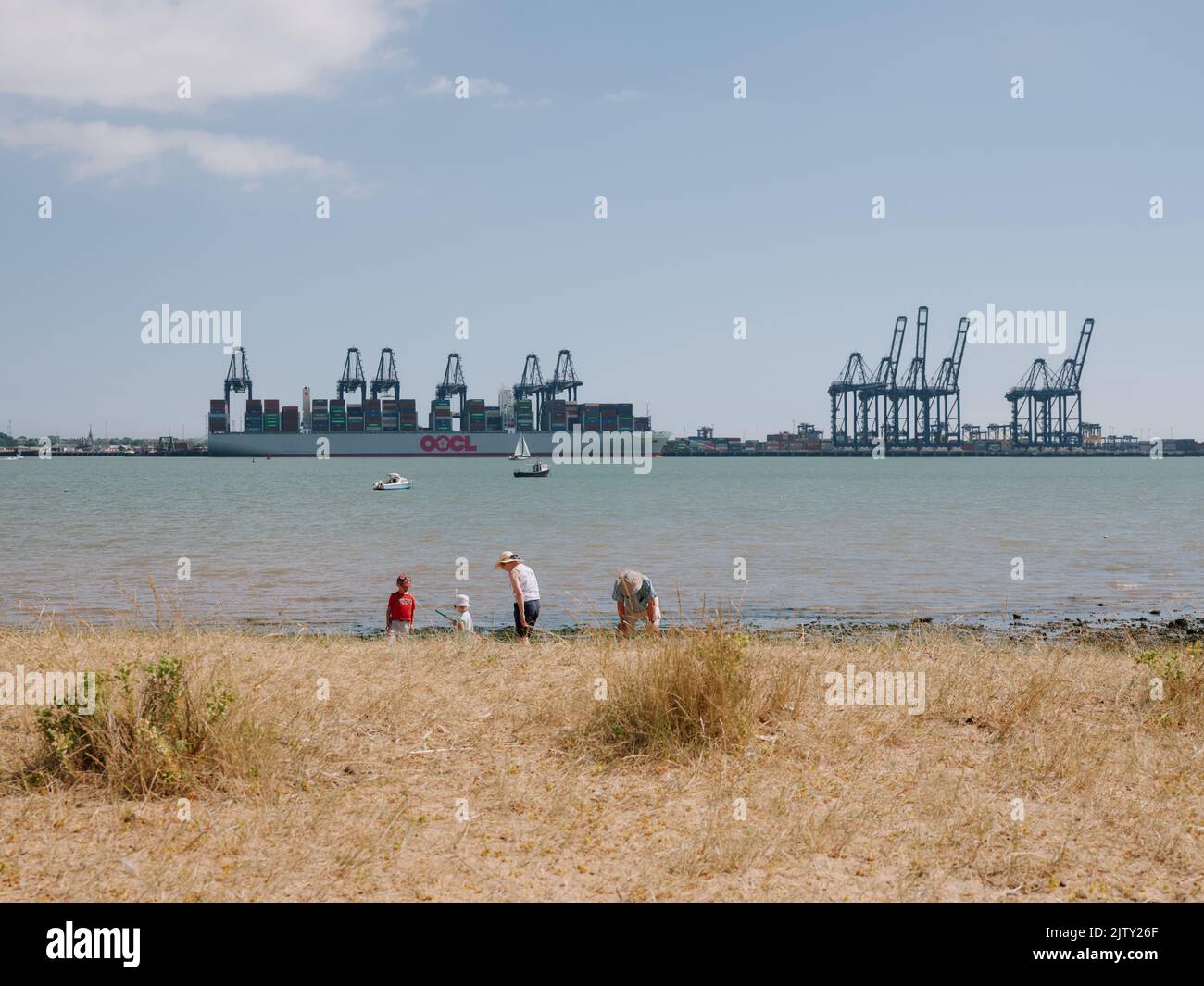 Summer visitors enjoying the beach and coast seaside of Harwich looking ...