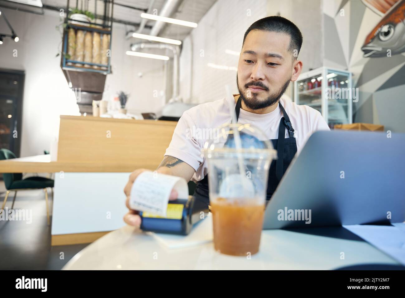 Professional coffee shop worker making a copy of a payment receipt ...