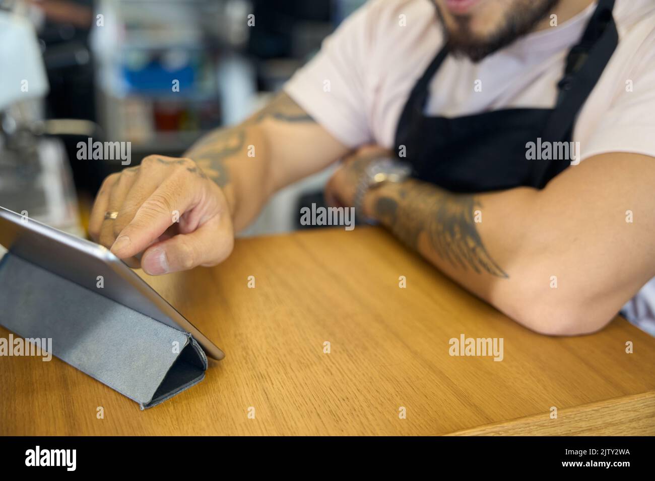 Busy coffee shop worker using tablet to calculate a receipt Stock Photo ...