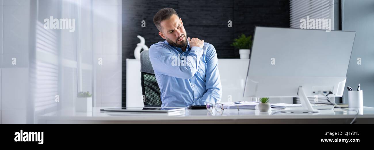 Posture Fatigue Shoulder Pain. Mature Man At Computer Workstation Stock ...