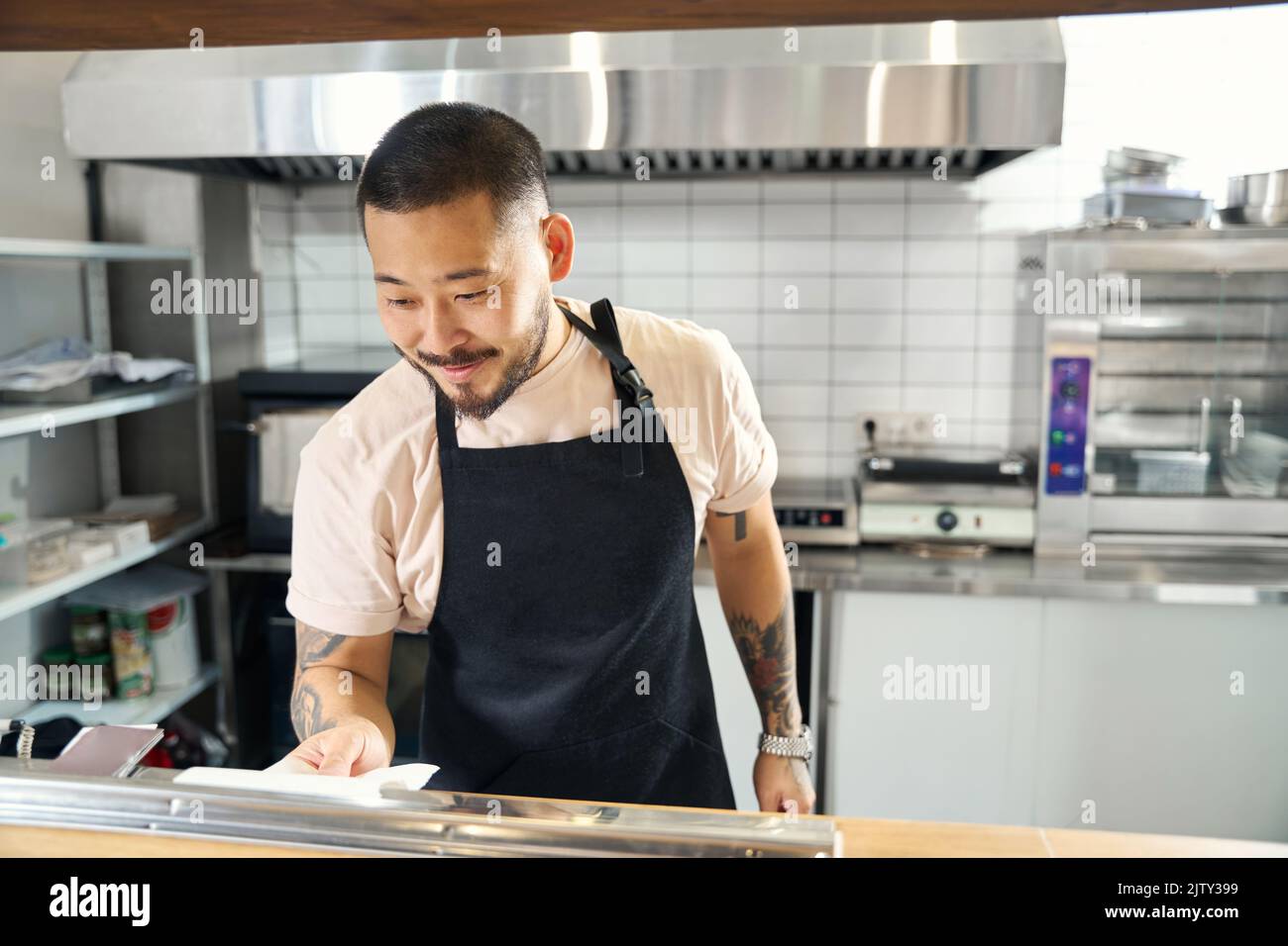 Radiant young Asian man enjoying his job as restaurant chef Stock Photo ... Radiant young Asian man enjoying his job as restaurant chef Stock Photo ...