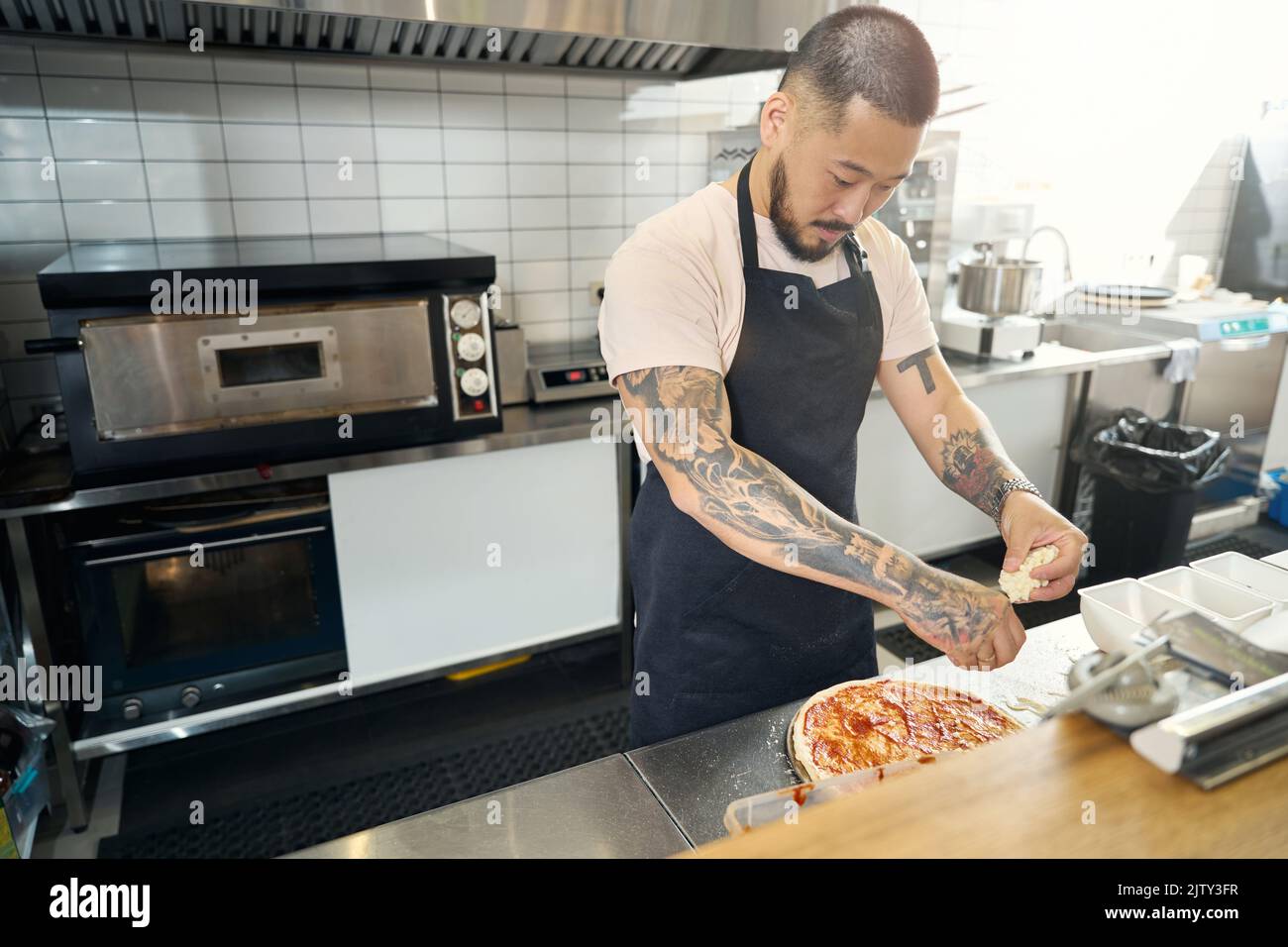 Chef putting cheese on pizza hi-res stock photography and images - Alamy