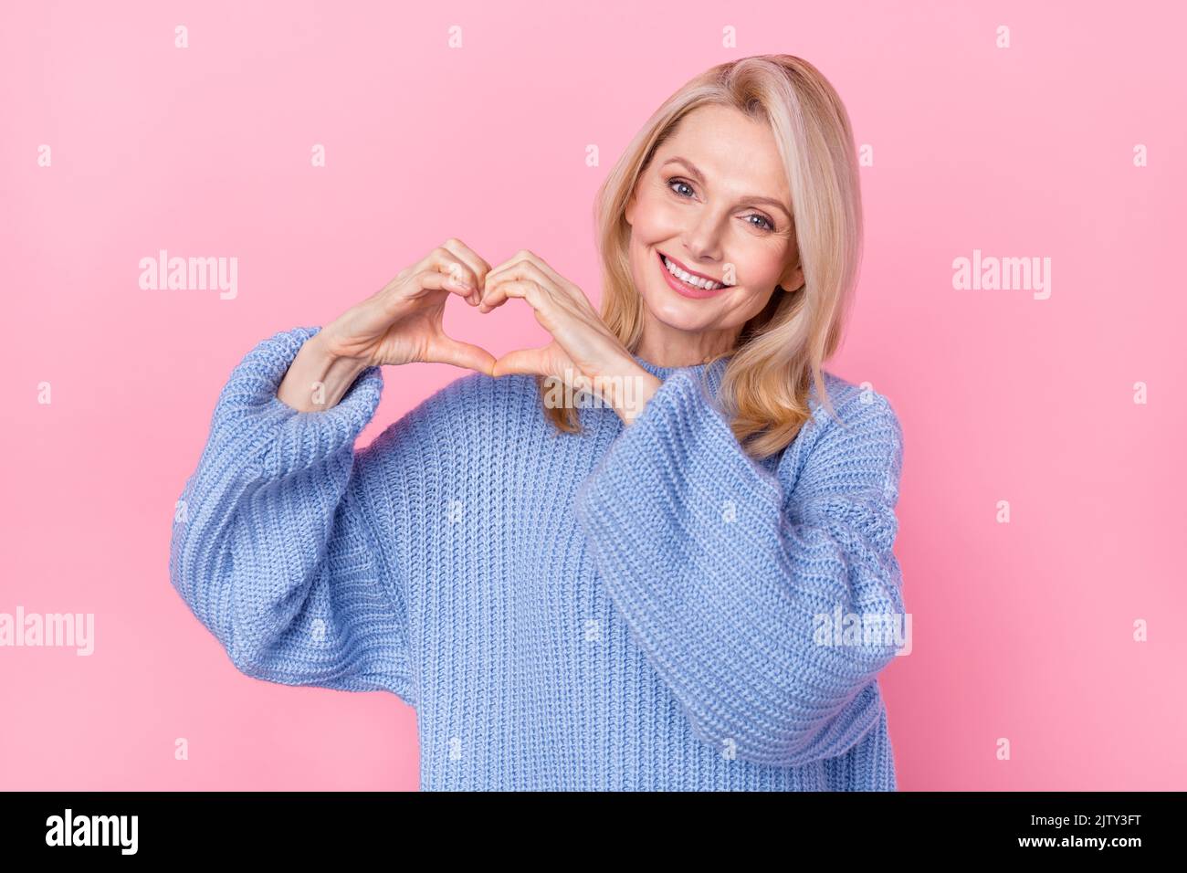 Photo of senior funky blond lady hands heart wear blue sweater isolated ...