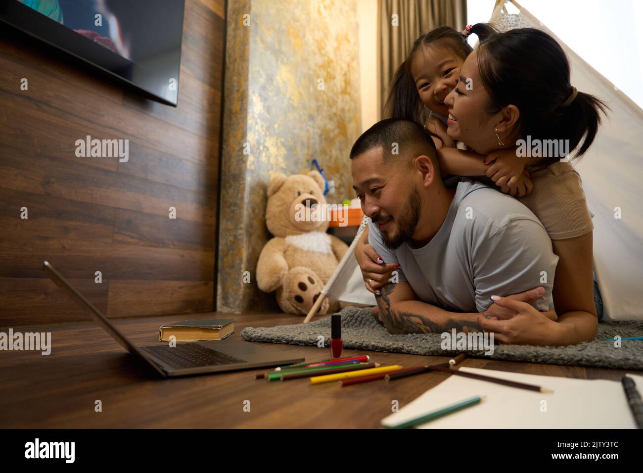 Asian parents and cheerful daughter play in the children room Stock ...