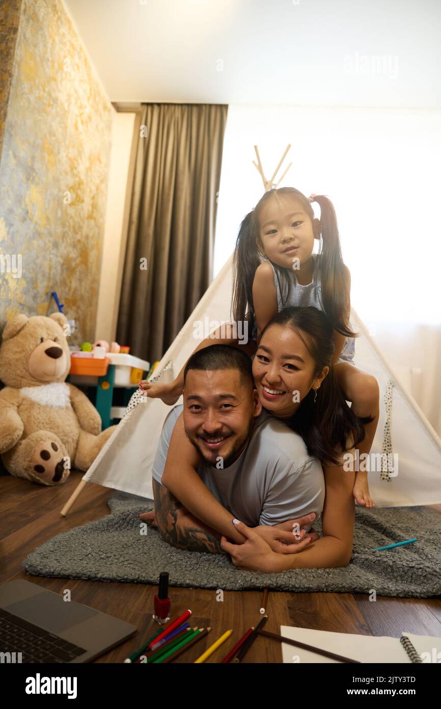 Smiling mom and daughter sitting on dad back Stock Photo - Alamy