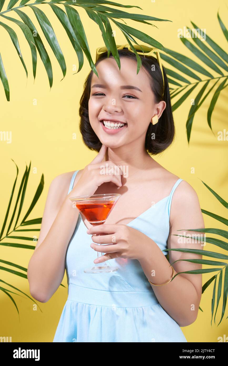 Happy Vietnamese woman drinking tasty cocktail, palm leaves around ...