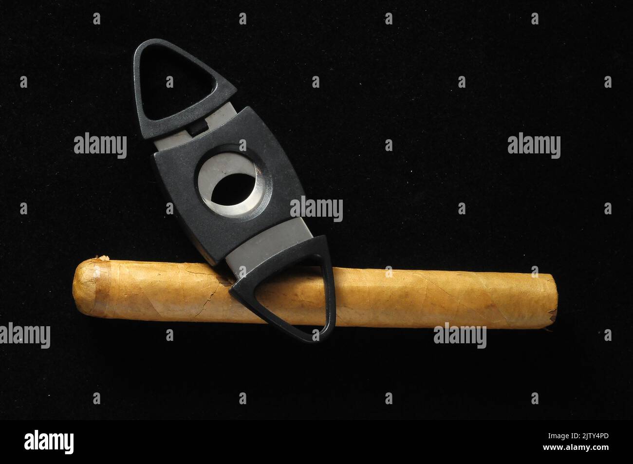 A Cuban Brown Cigar and Cutter on a black background Stock Photo - Alamy