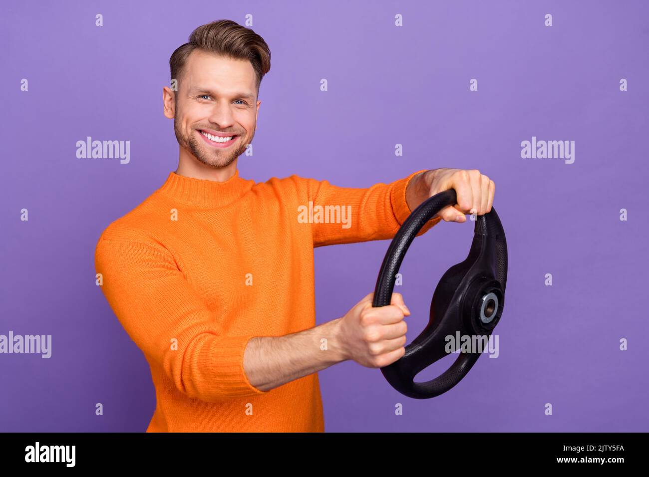 Photo of funny adorable guy wear orange sweater driving car holding ...