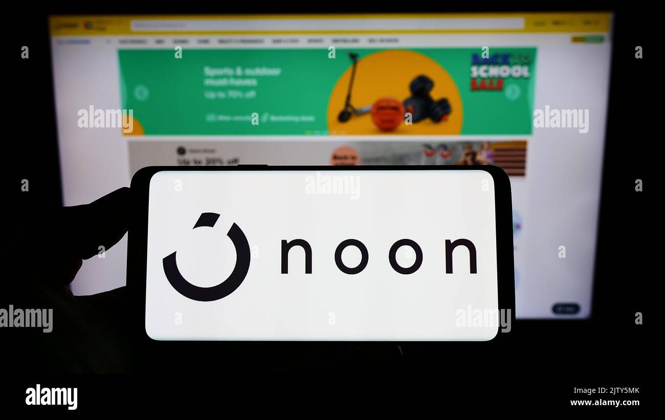 Person holding smartphone with logo of e-commerce company Noon AD ...