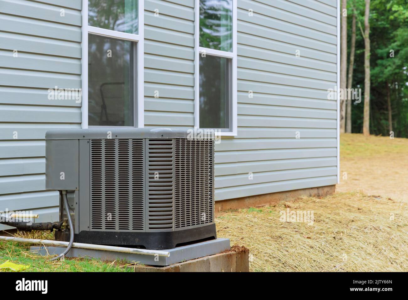 In the vicinity of a new house, an electric air conditioner is being ...