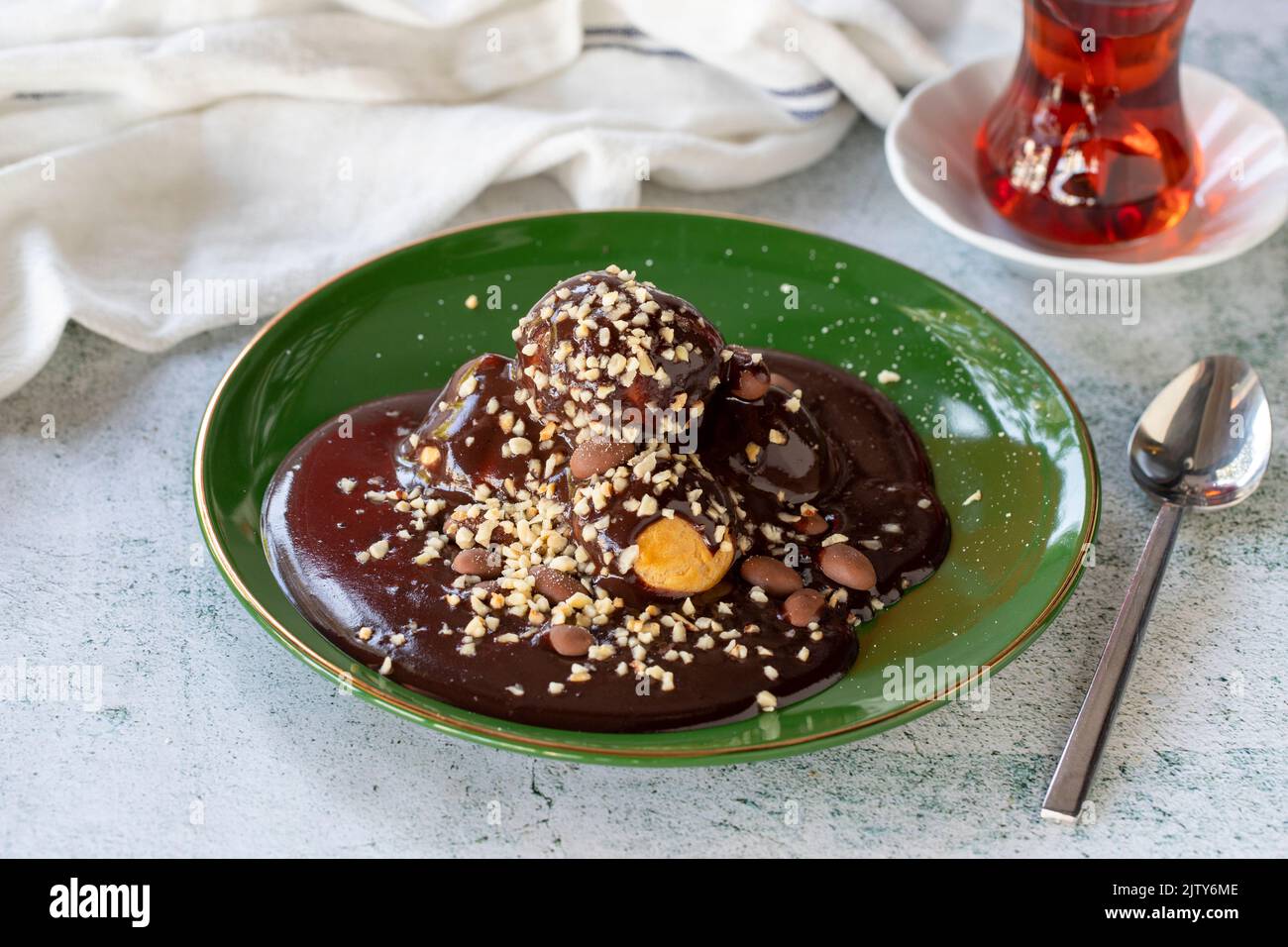 Profiterole. Chocolate profiteroles dessert on plate on gray background ...