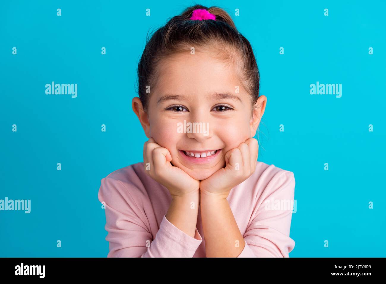 Photo of adorable sweet kid arms touch cheeks toothy smile look camera ...