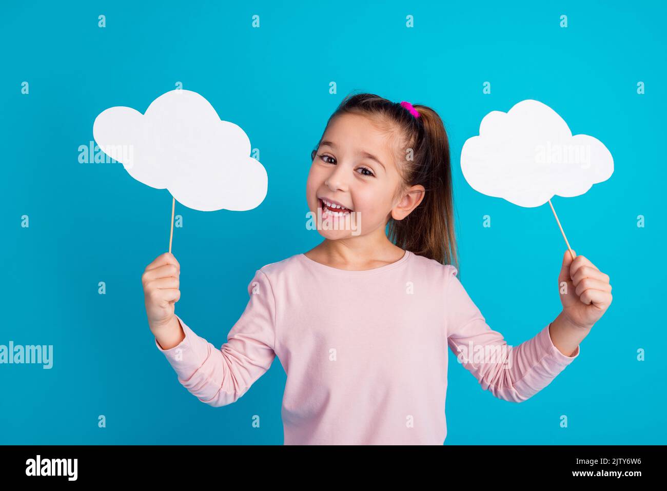Portrait of positive cute girl hold two empty space paper cloud cards ...