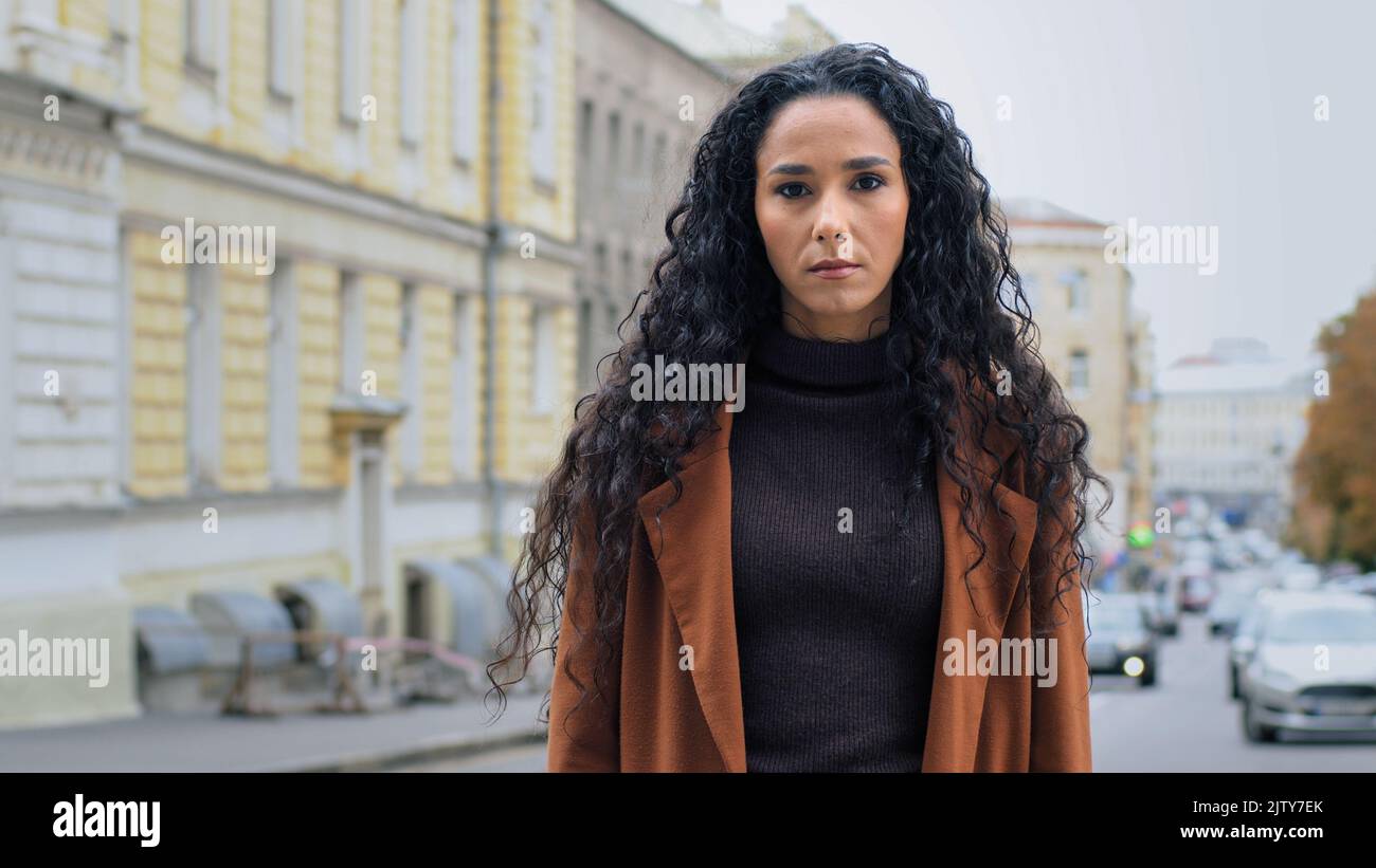 Serious alone confident powerful young brunette girl with long curly ...