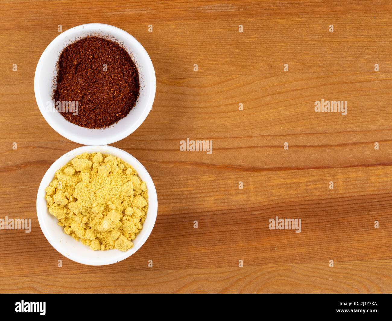 Yellow mustard and red Chilli powder in White bowls on a table ...