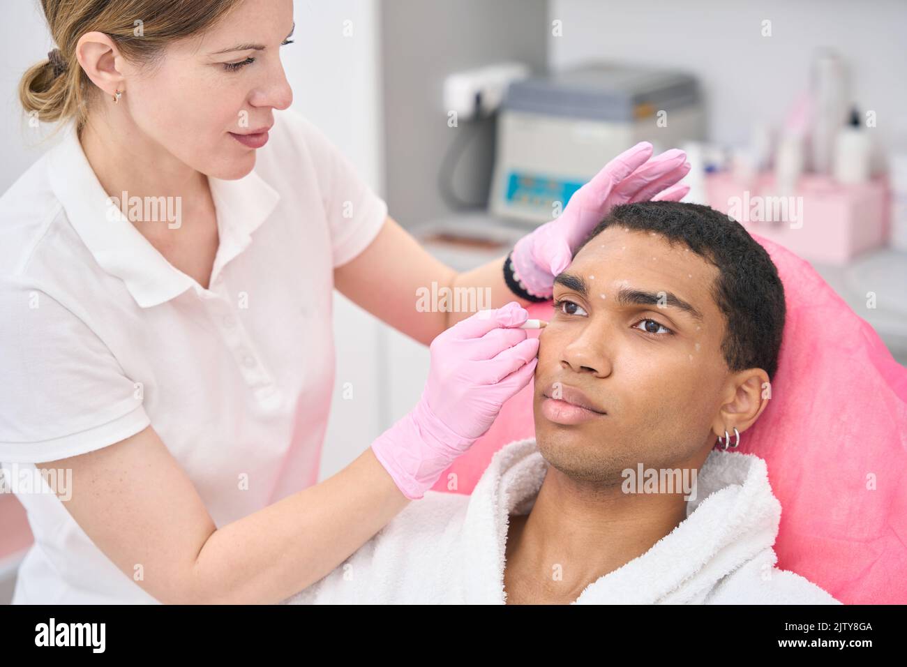 Experienced doctor preparing male client for cosmetic procedure Stock ...