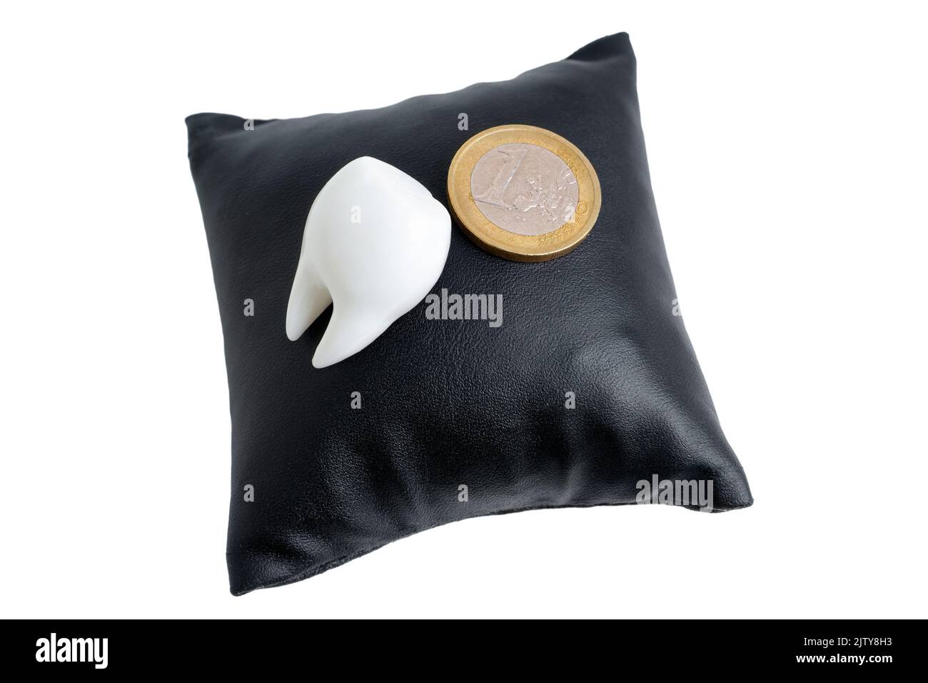 Black leather pillow with a white tooth and a one euro coin on top ...