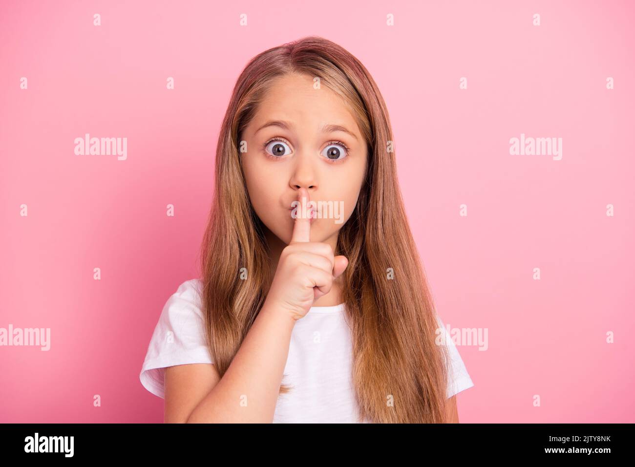 Portrait of little nice girl finger cover touch lips demonstrate shh ...