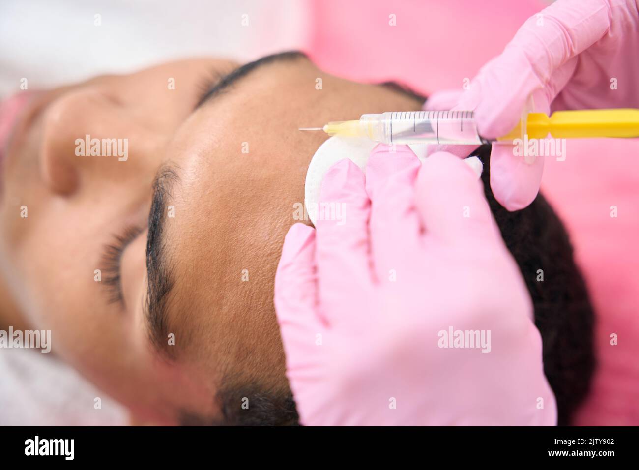 Man receiving forehead filler injection in beauty salon Stock Photo - Alamy