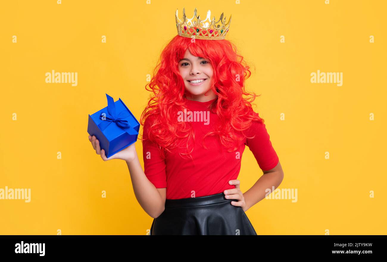 smiling child in princess crown with present box on yellow background ...