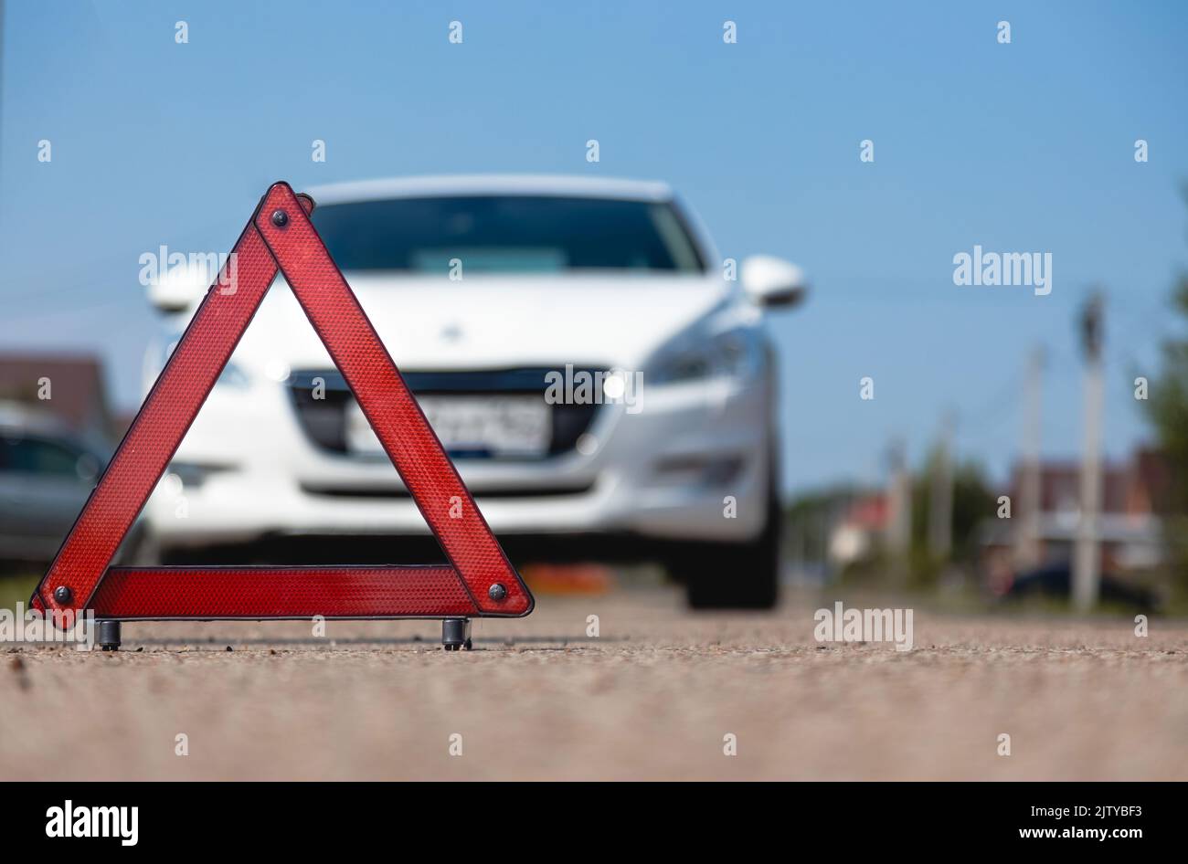 Car breakdown concept. Warning stop triangle close-up on the background ...