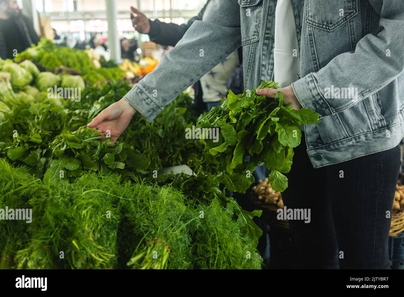 Buying fresh organic produce at the farmers' market. A woman chooses ...