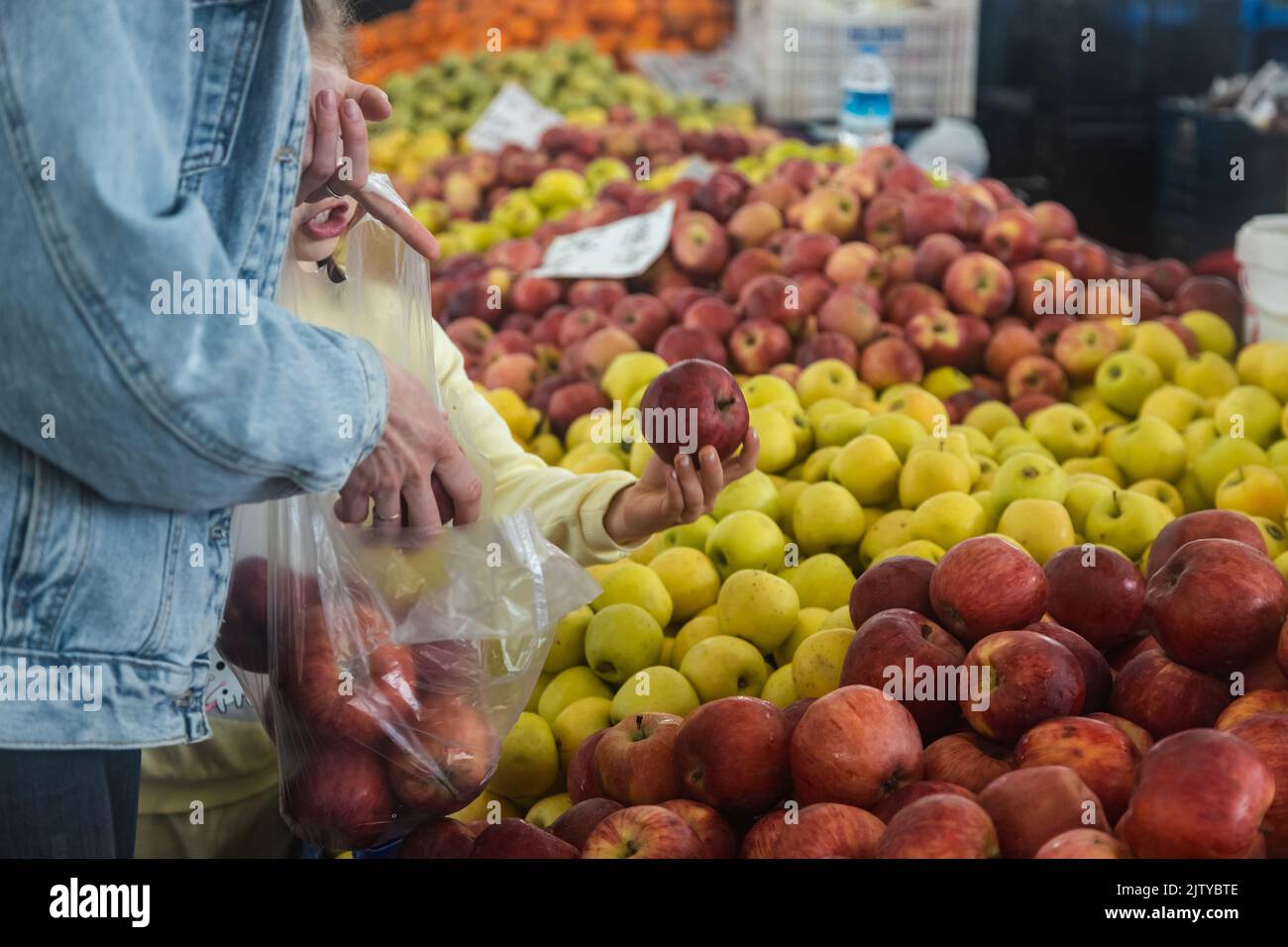Buying fresh organic produce at the farmers' market. A woman chooses ...