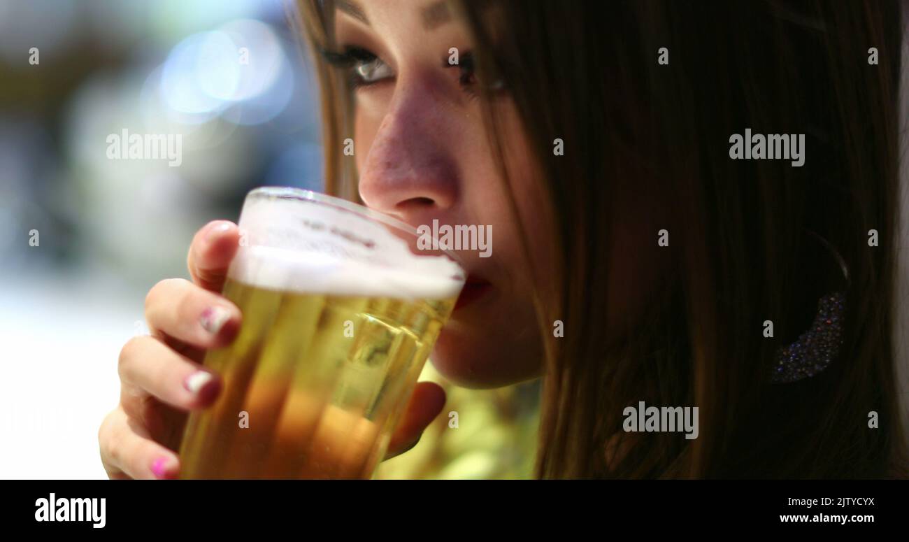 Pretty girl taking a sip of beer Stock Photo - Alamy