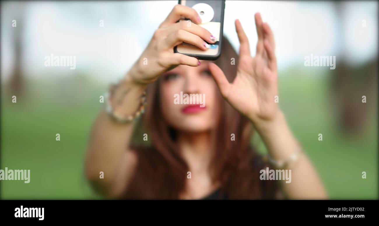 Pretty girl taking selfie outside at park Stock Photo - Alamy