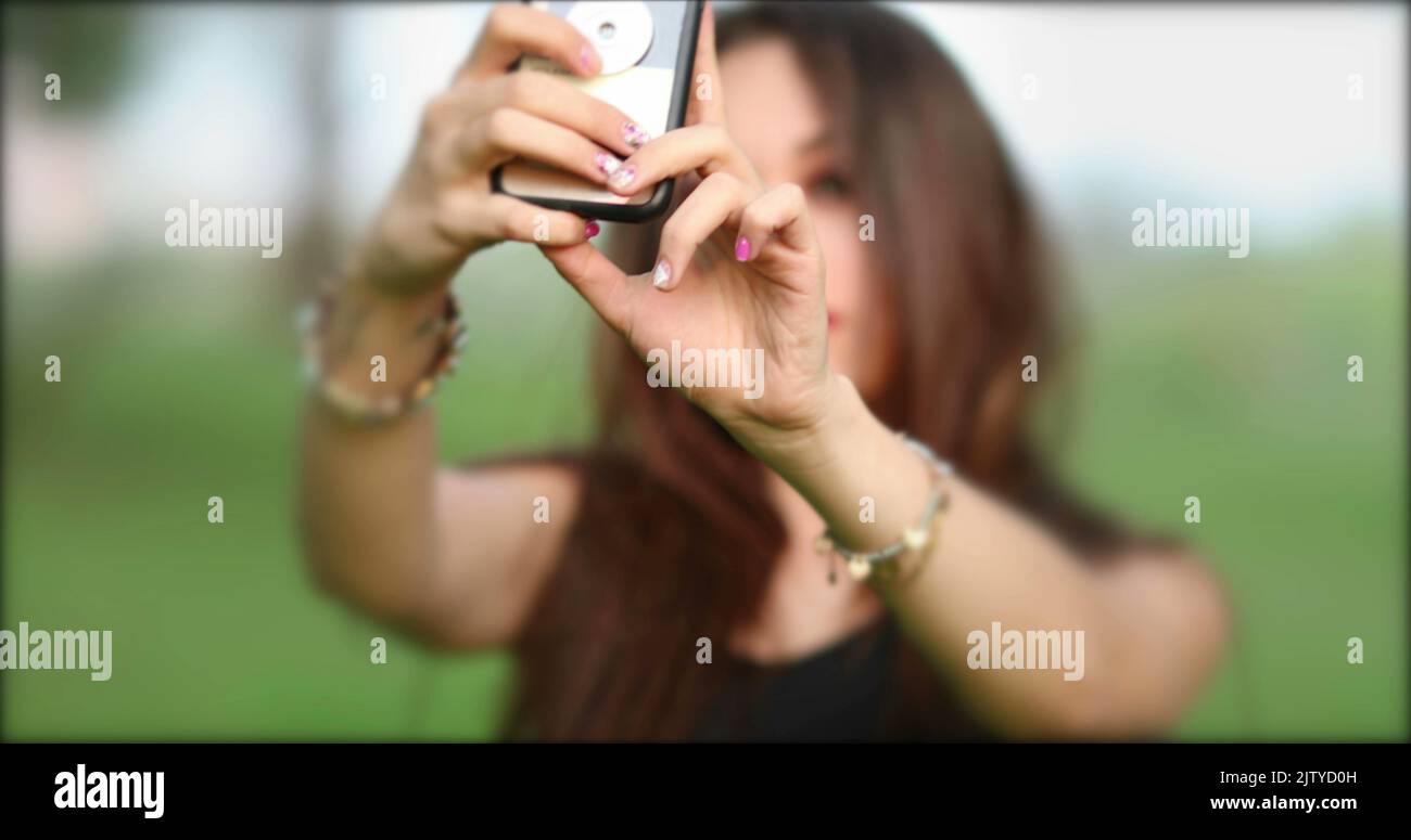 Pretty girl taking selfie outside at park Stock Photo - Alamy