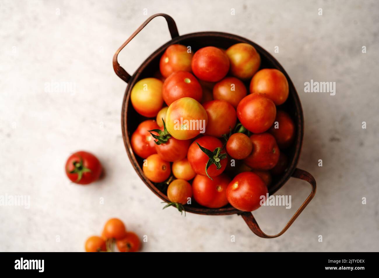 Still life of homegrown fresh cherry tomotoes in a basket with copy ...