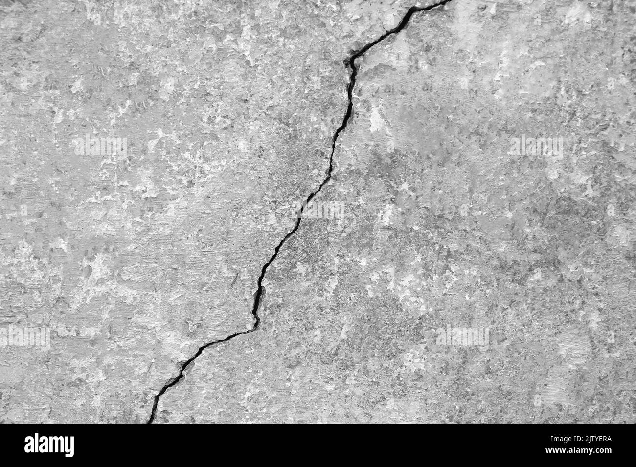 Big diagonal ascending crack on old concrete wall. Black and white ...