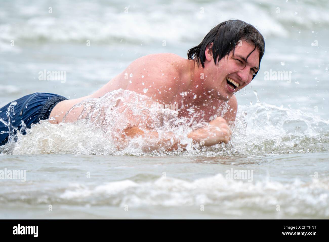 Man playing on the beach Stock Photo - Alamy