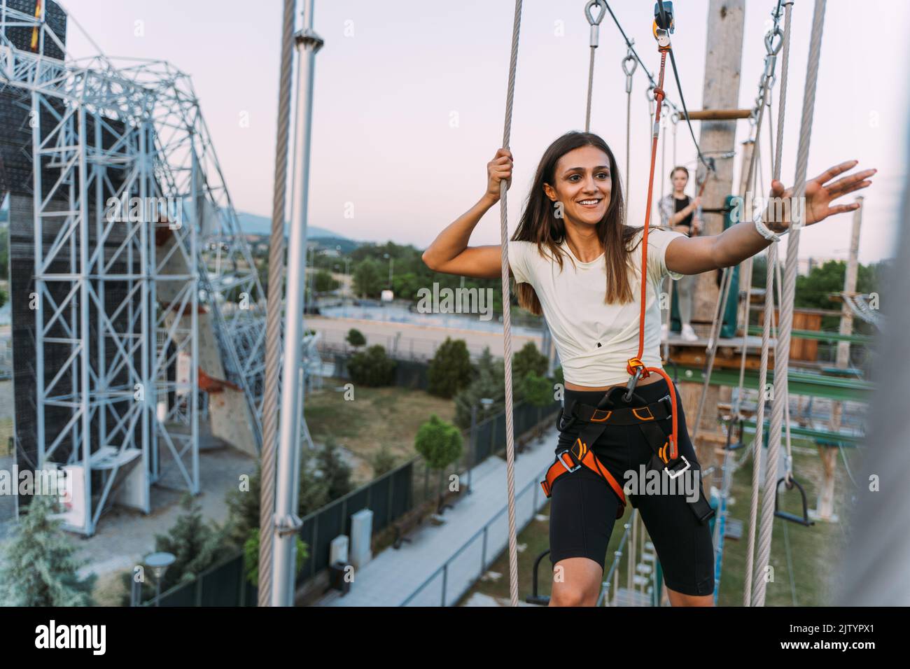 Athletic young girl going through the ropes in the adventure park Stock ...