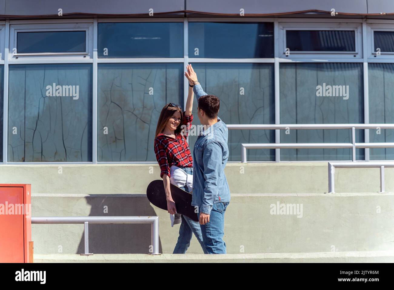 Cute couple high fiving in between the buildings while standing Stock ...